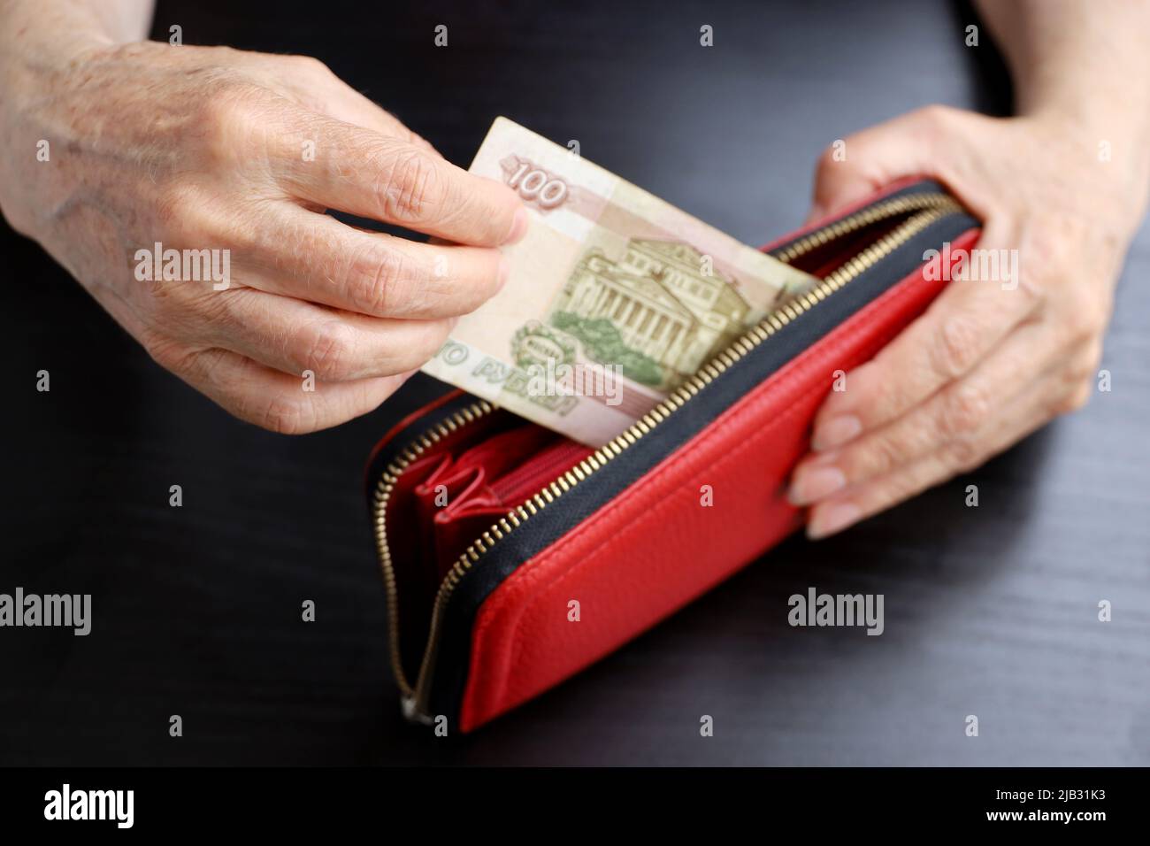 Elderly woman takes out russian rubles from red wallet, wrinkled female ...