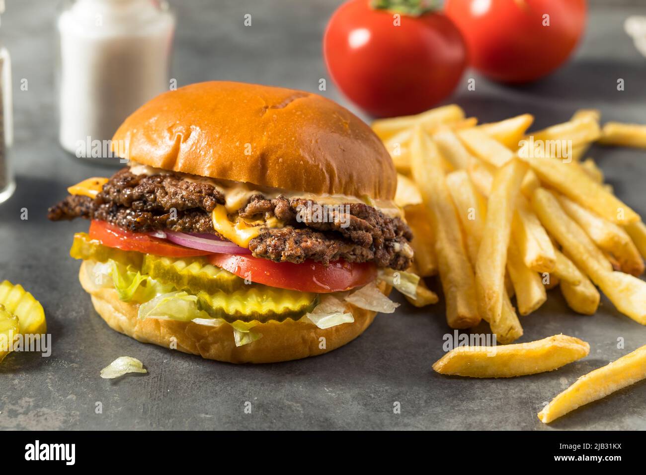 Homemade Cheese Smash Burger with Fries Pickles and Tomatoes Stock ...