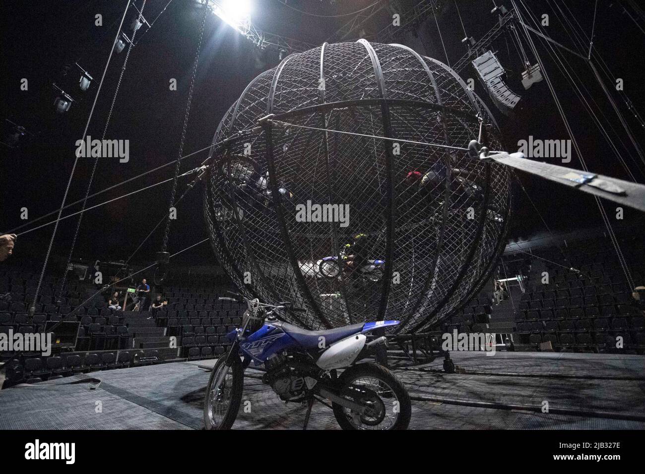 Motorcycle artists ride their motorcycles in a steel cage, set-up ...