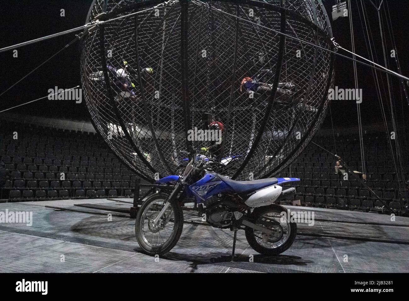 Motorcycle artists ride their motorcycles in a steel cage, set-up ...