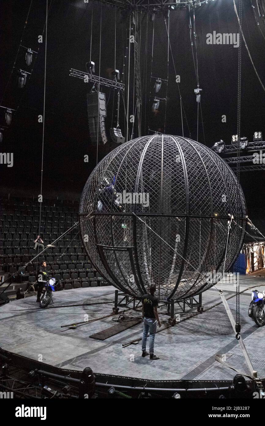 Motorcycle artists ride their motorcycles in a steel cage, set-up ...