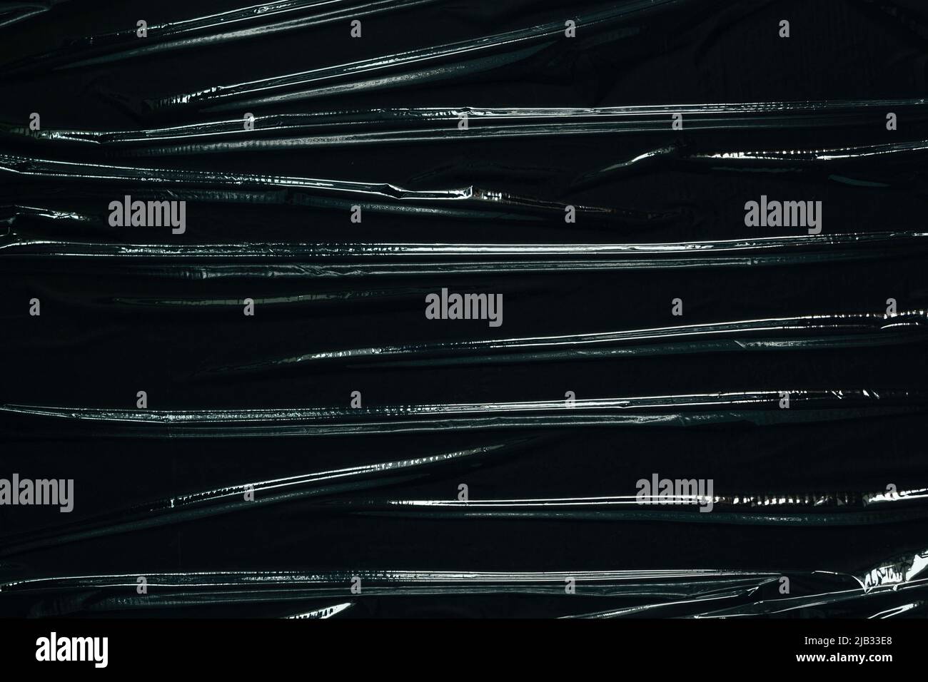 Black plastic wrap background. Crumpled wrinkled plastic cellophane ...