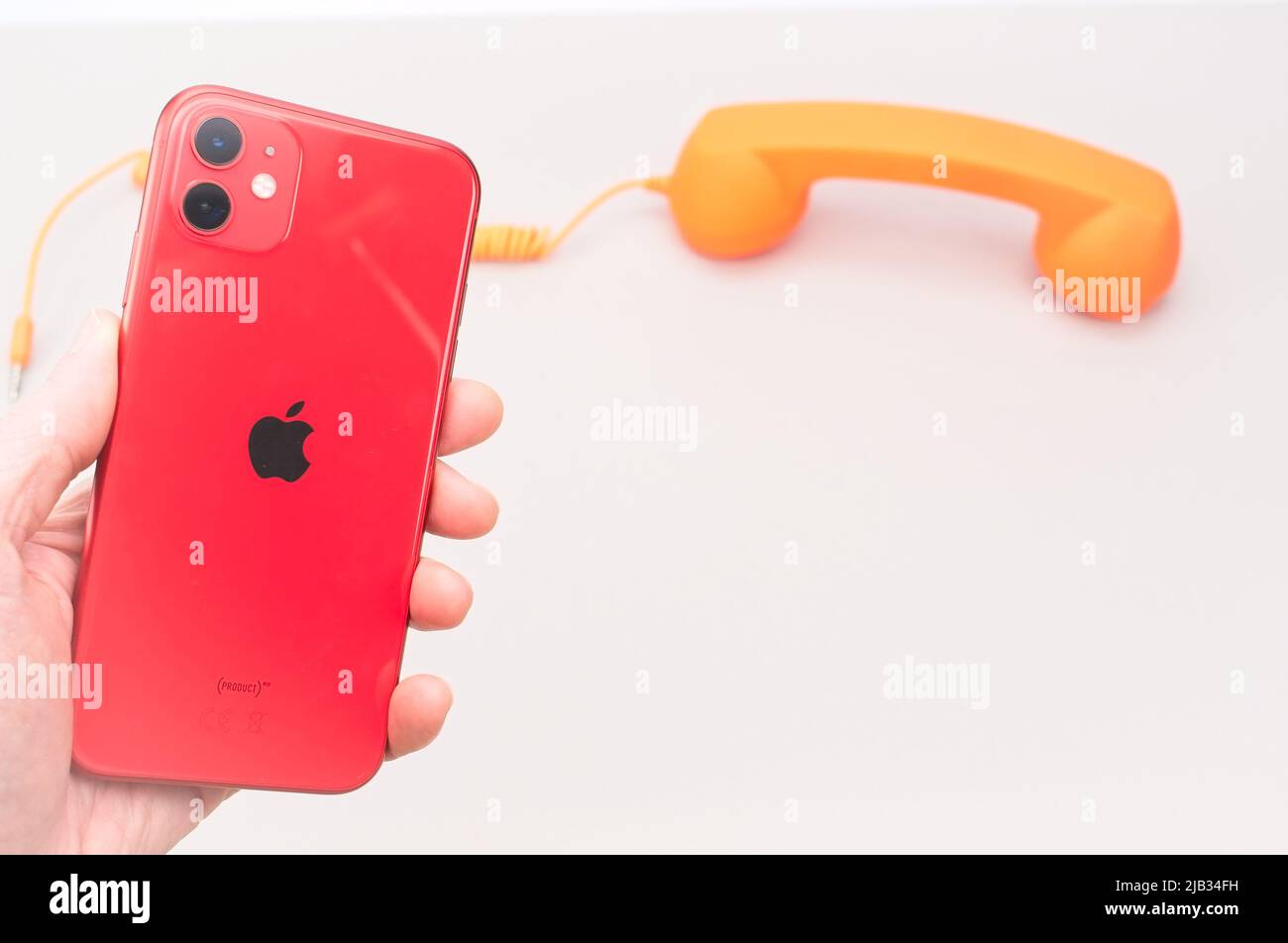 Apple iphone Product Red and old rotary phone handset on a bright desk ...