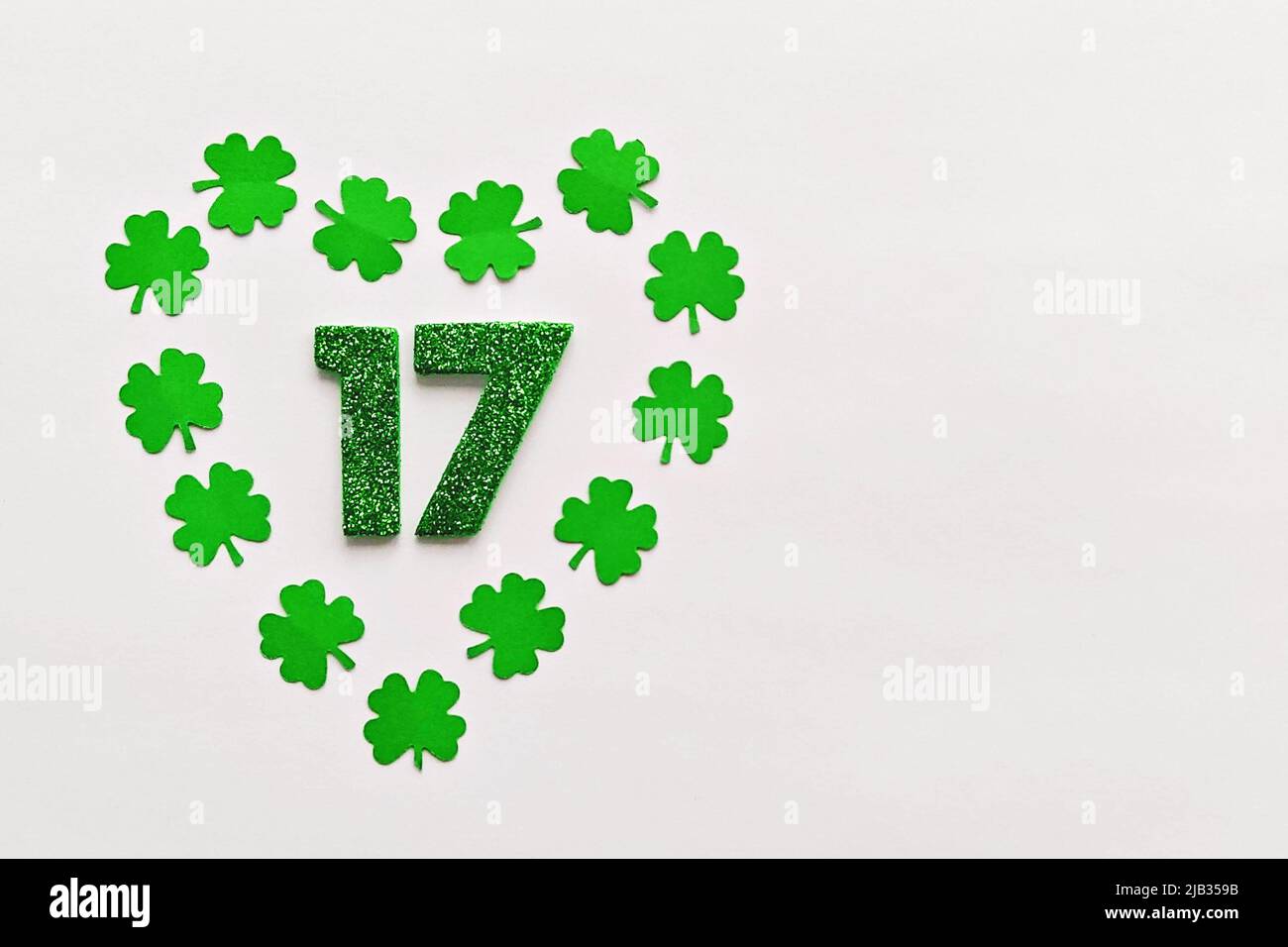Numeral 17 on white background with heart frame of paper-cut four-leaf ...