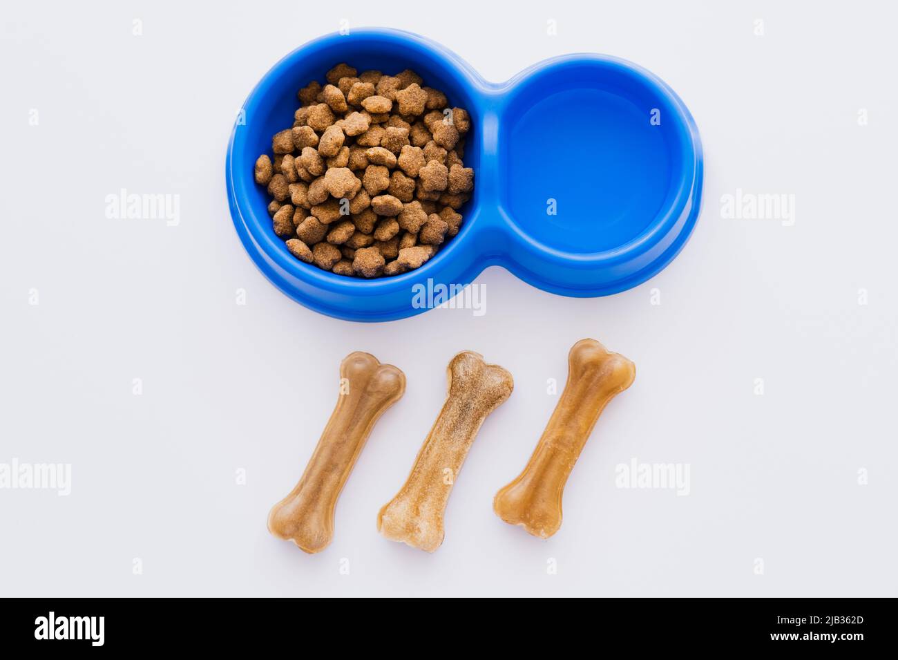 top view of bone shaped pet treats near bowl with water and dry pet ...