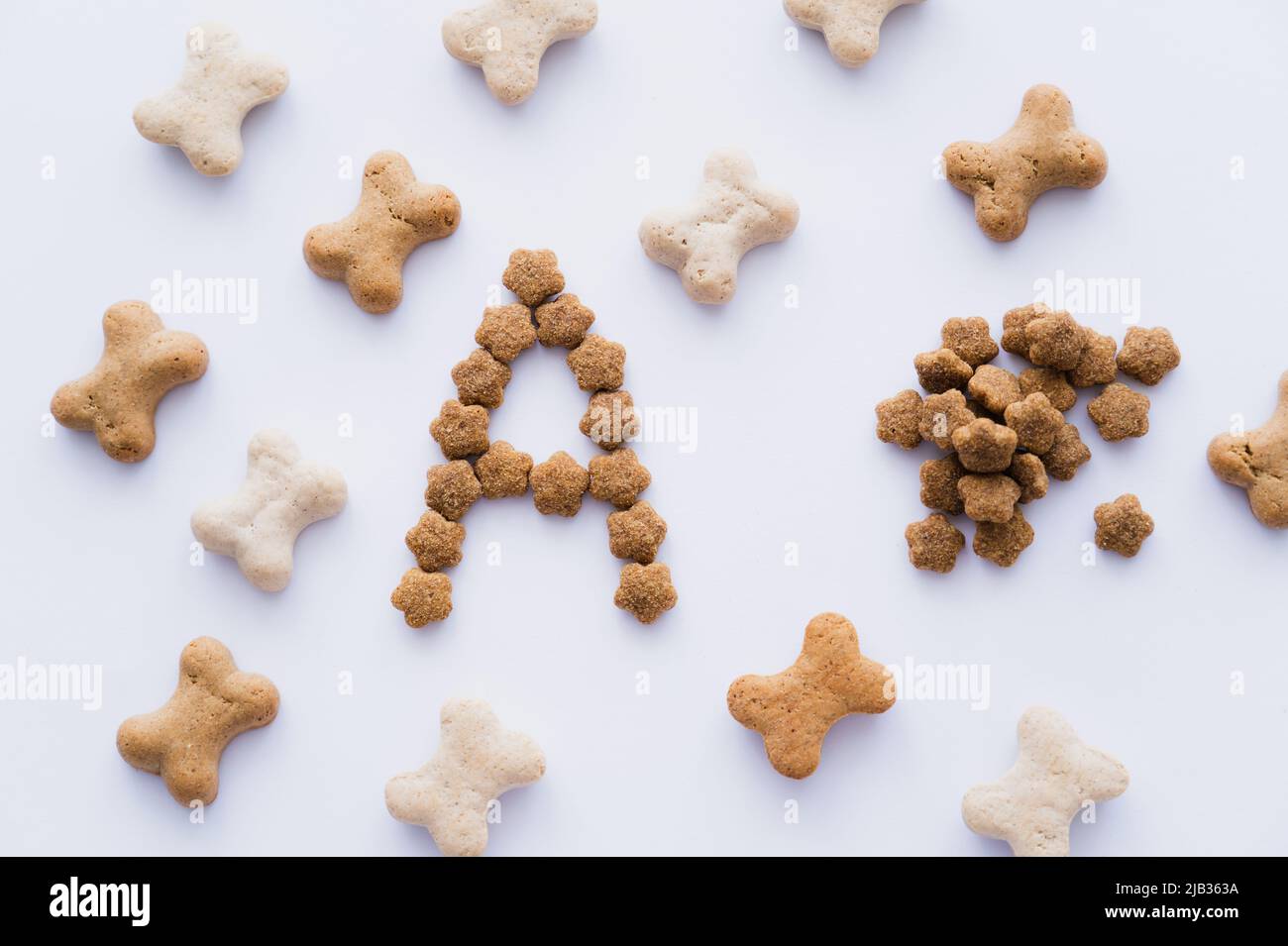 top view of bone shaped pet treats near letter and dry pet food ...