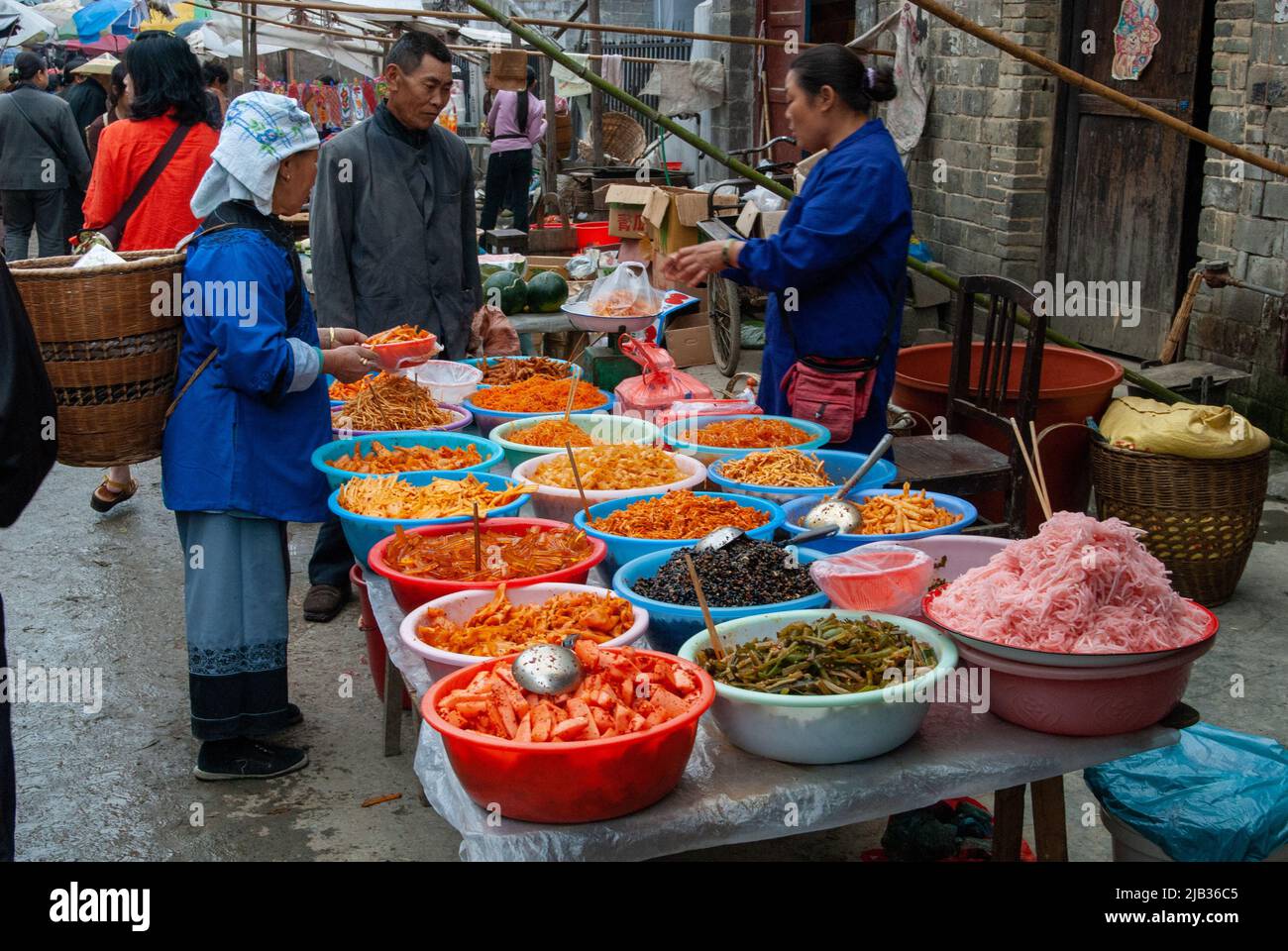 Cold snack stall at a village market in China. Lady on the left has the ...