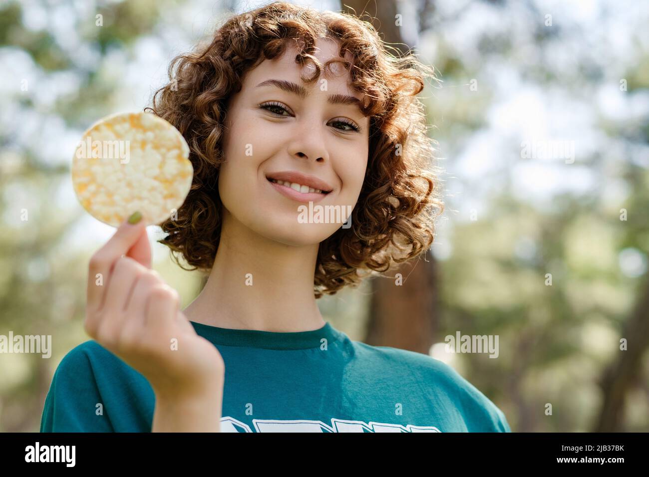 Happy Redhead Woman Wearing Green T Shirt Standing On City Park