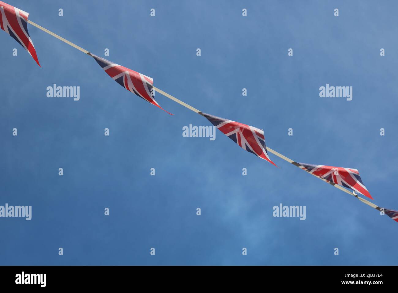 Platinum Jubilee Union Jack bunting across deep blue sky with copy ...
