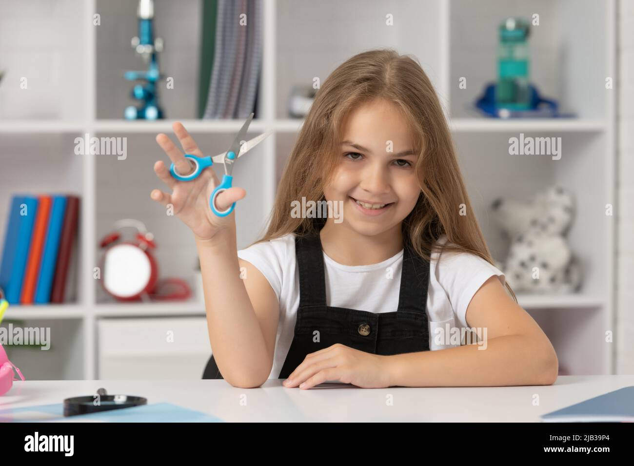 happy girl hold scissors in school classroom Stock Photo - Alamy