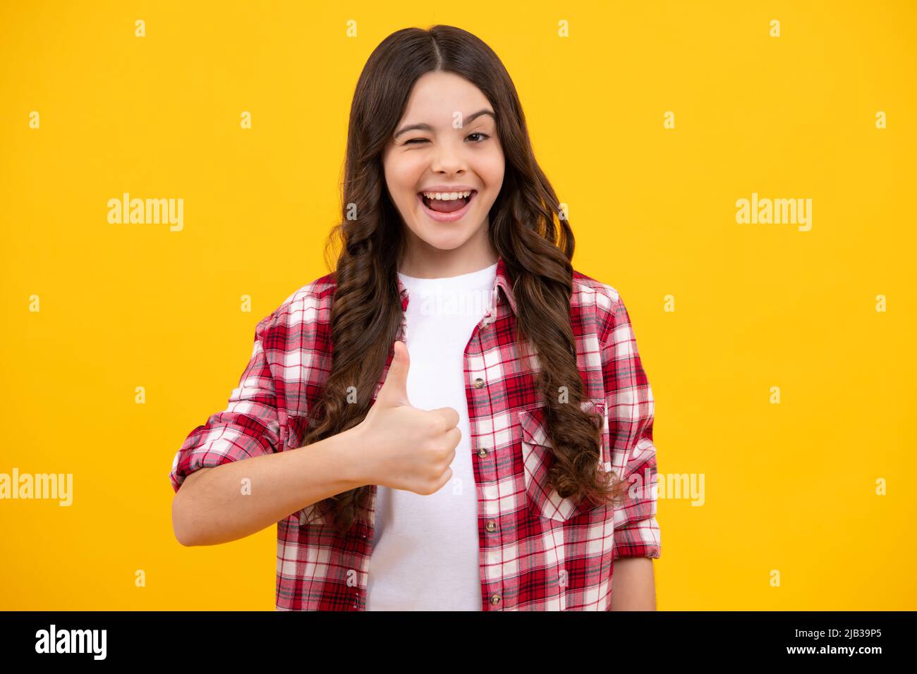 Portrait of a happy casual teenager child girl showing thumbs up and ...