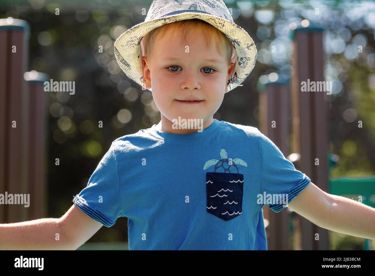 Adorable European boy in blue shirt and hat, smiling, happy playing in ...