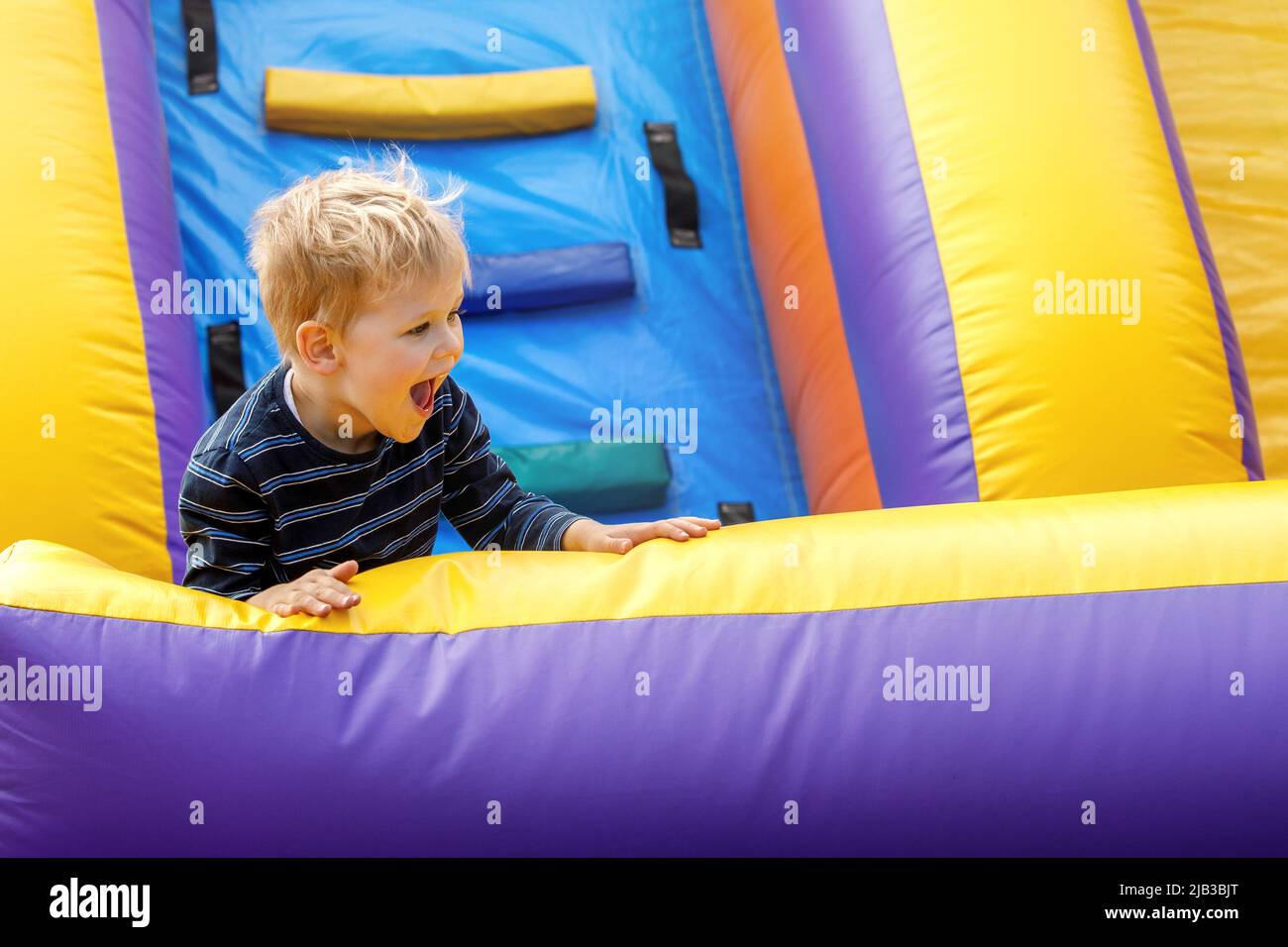 Joyful child jumping on colorful inflatable trampoline. Little boy 3-4 ...