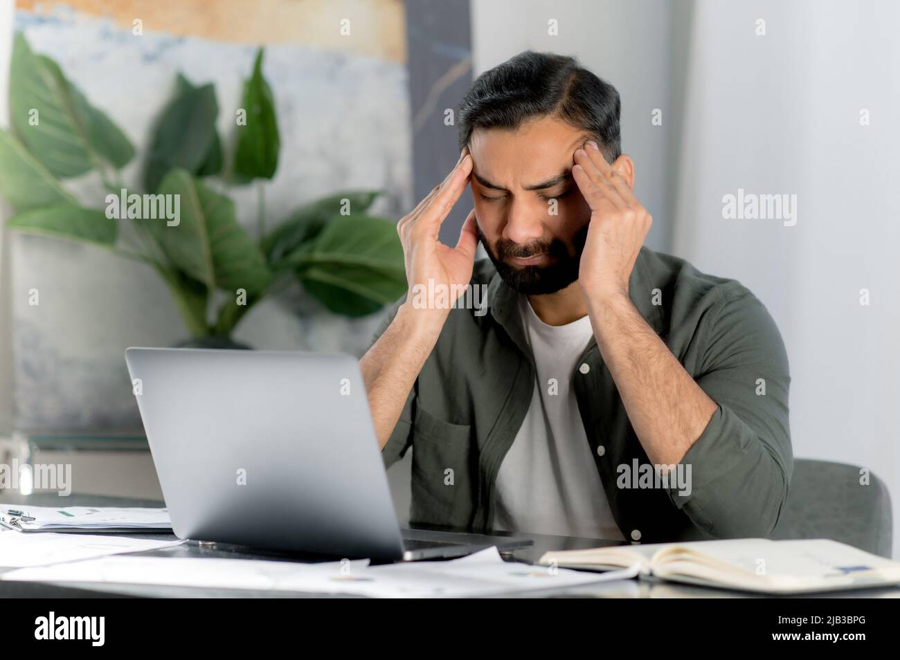 Headache and migraine. Exhausted indian or arabian man, manager ...