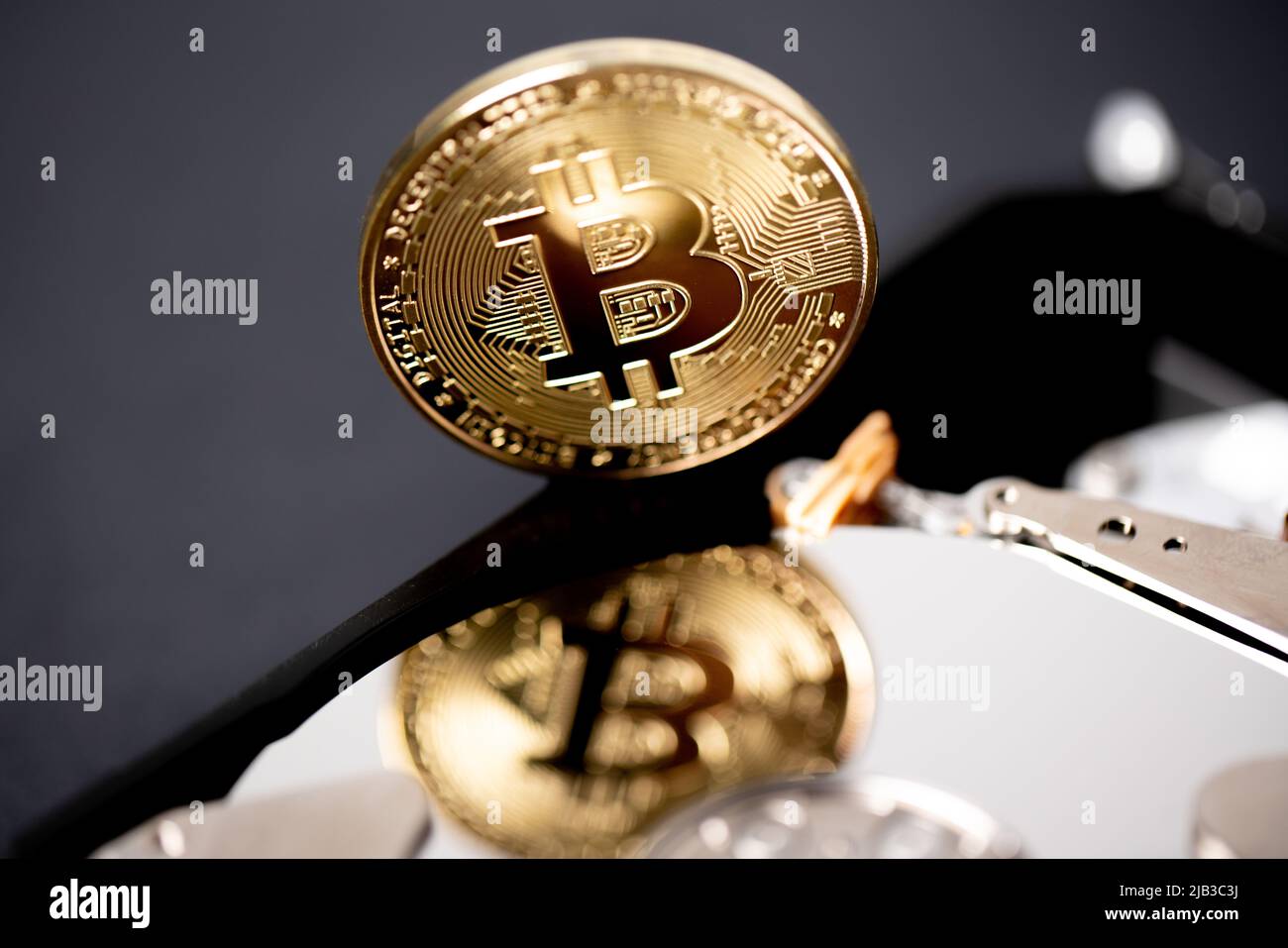 Gold bitcoin reflecting on hard drive platter of hard disk storage ...