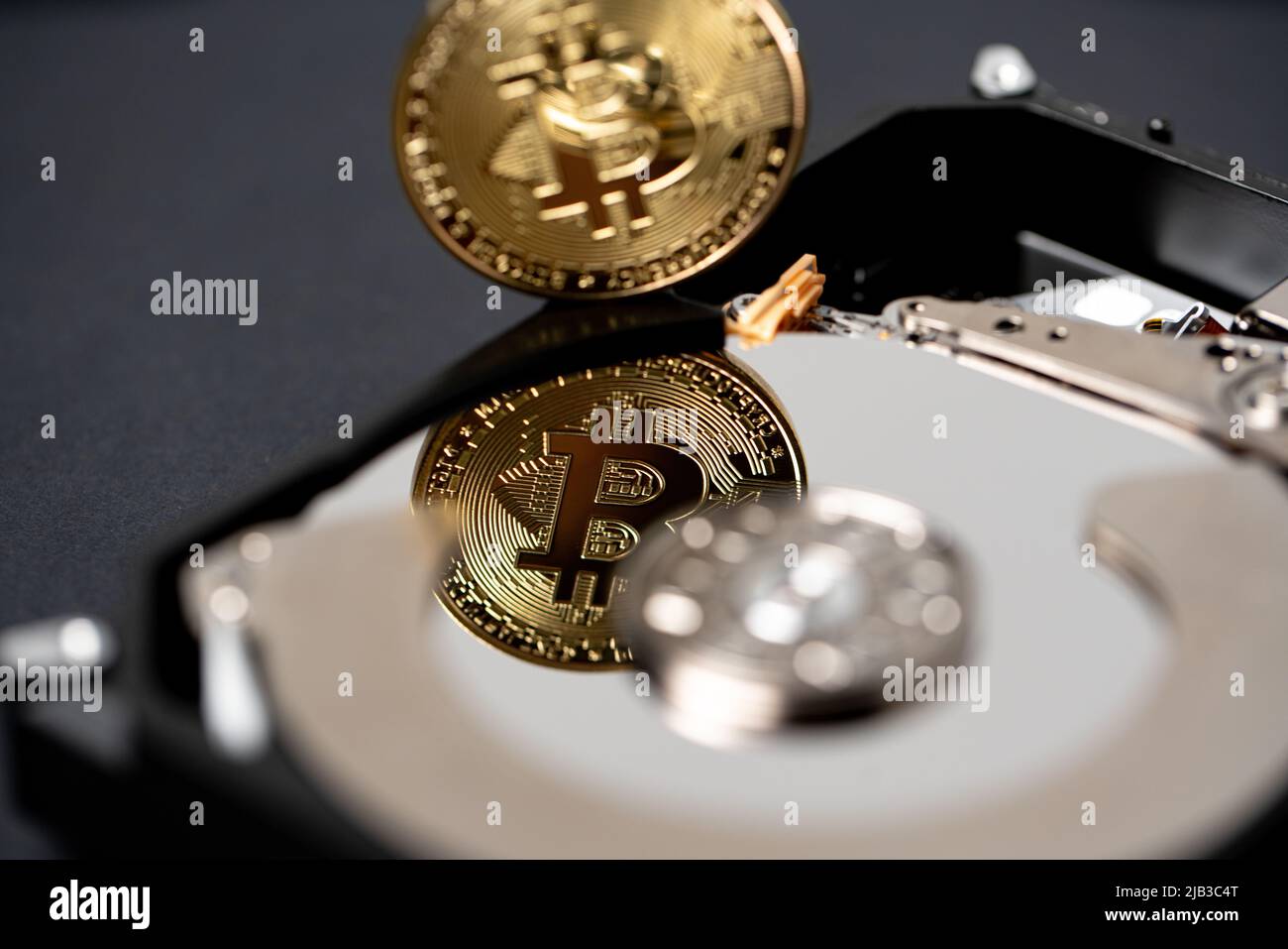 Gold bitcoin reflecting on hard drive platter of hard disk storage ...