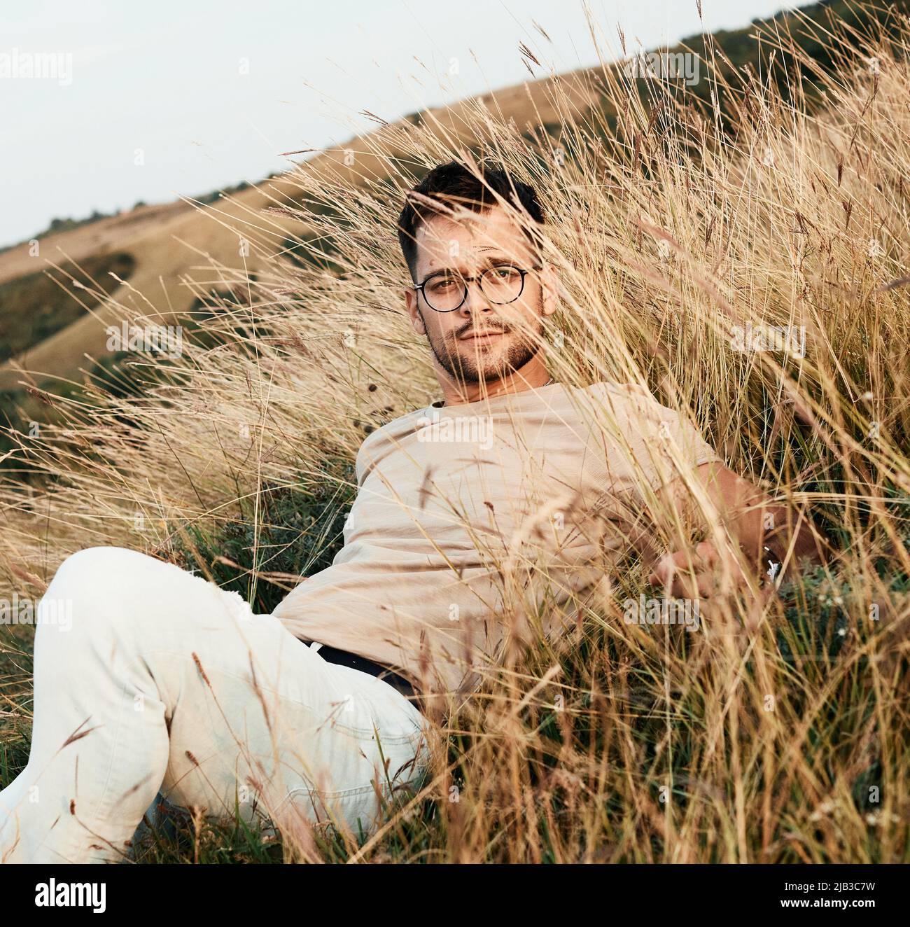 Portrait of a young man fashion model outdoors in the field Stock Photo ...