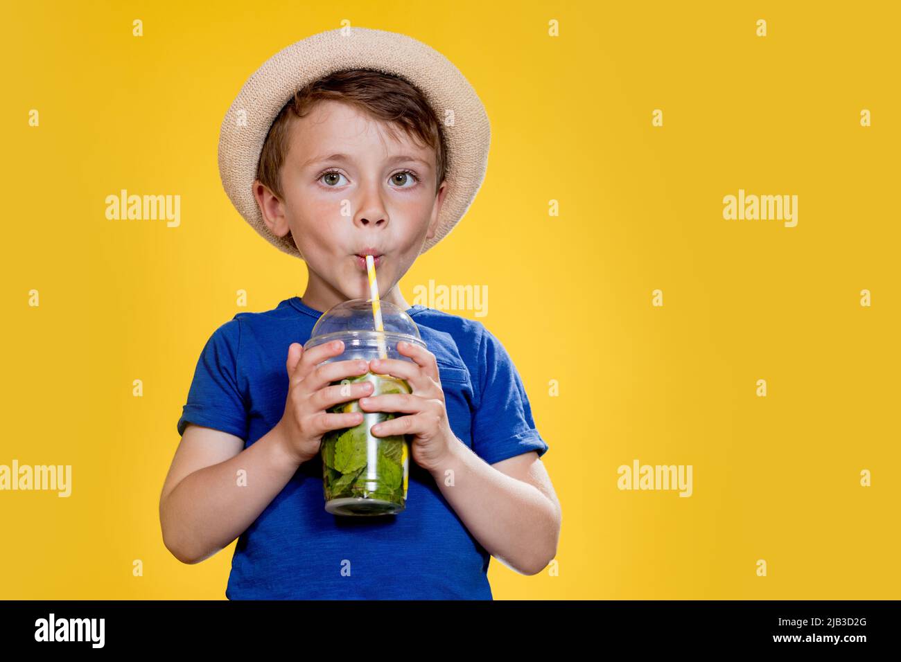 Cute boy Drink Mojito cocktail From Plastic Cup Over Yellow Studio ...