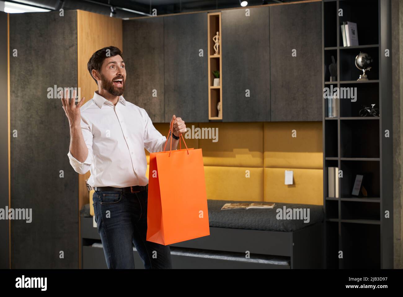 Side view of consumer holding purchases, bags in furniture store ...