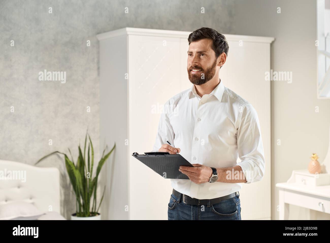 Side view of brunette male with beard designing furniture, interior ...