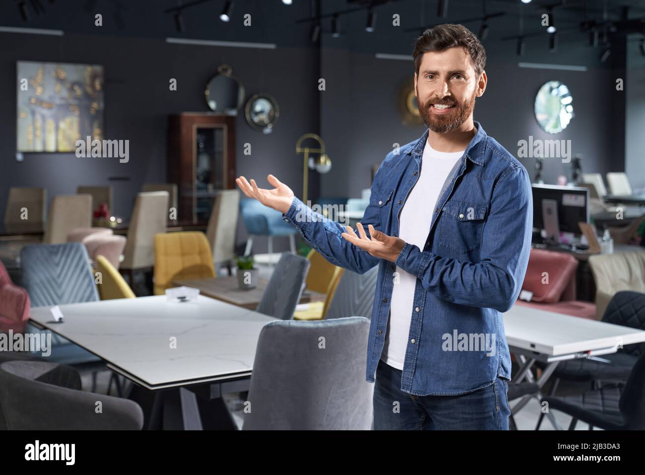Front view of handsome boy standing, representing furniture in store ...