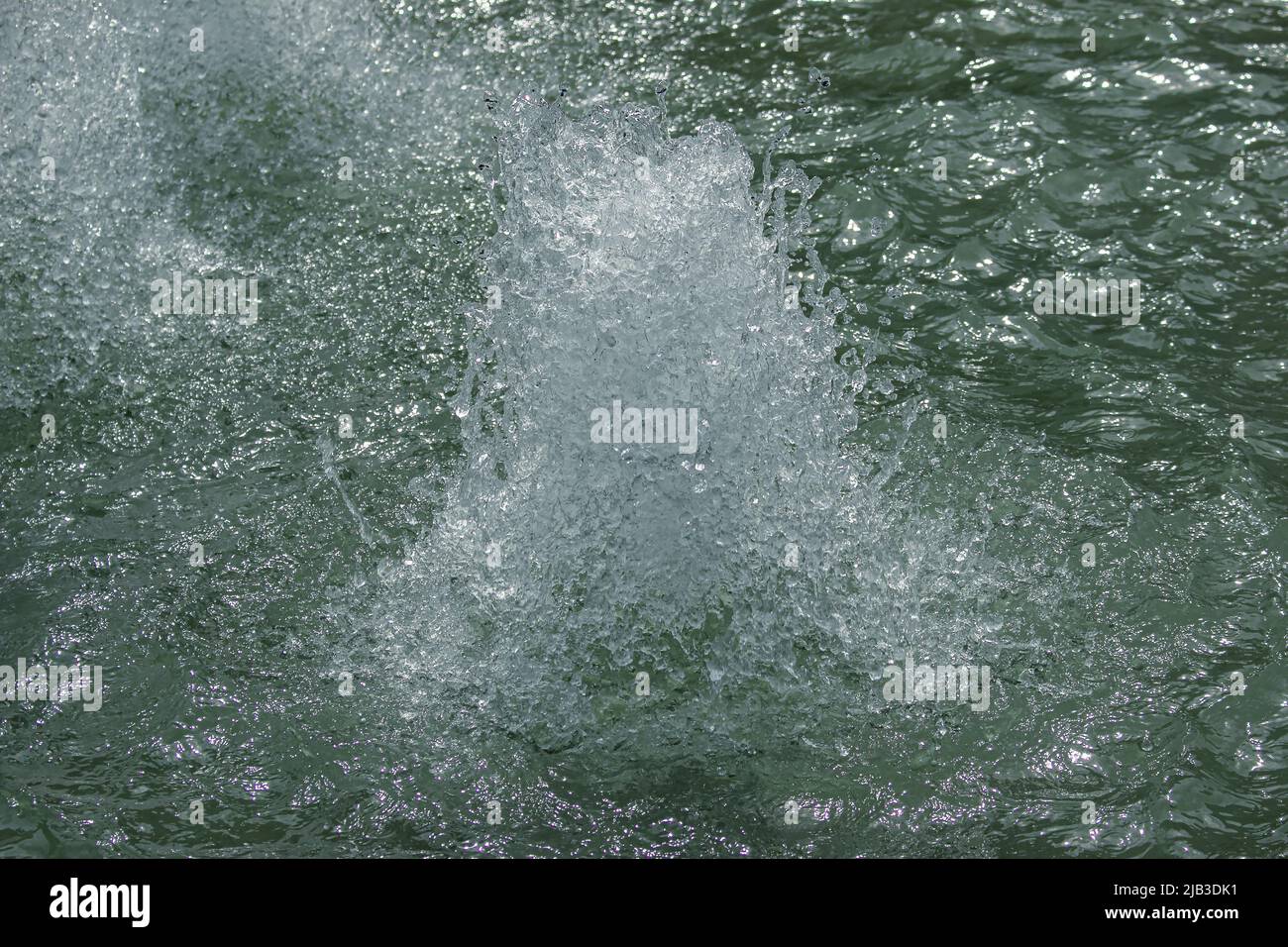 Close-up view of streams of fountain with reflection and lens flare ...