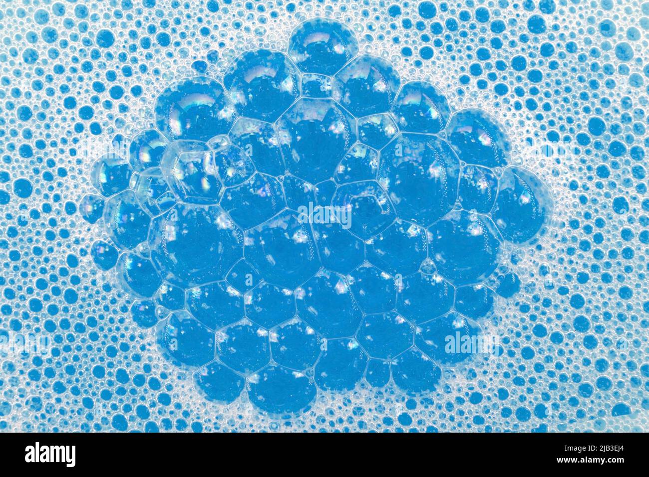 Soap foam in blue close-up. Foam bubbles on the surface of detergent or ...