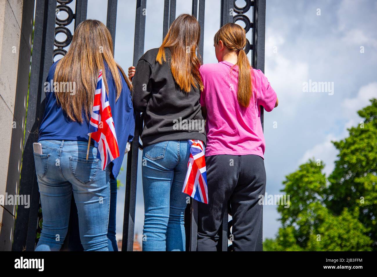 Fans stand on a large gate overseeing the parade during the Queen ...