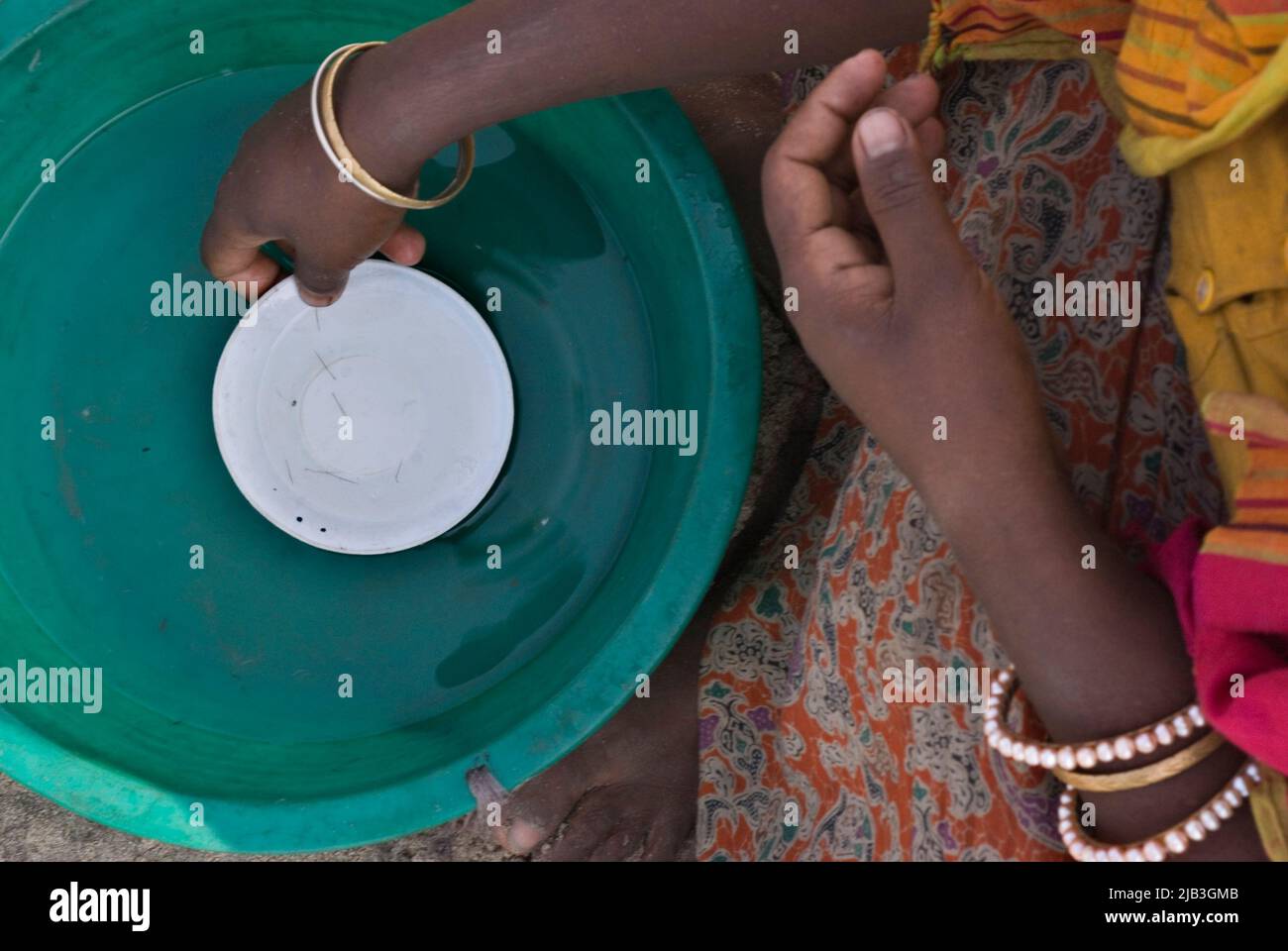 Woman sorting out the fish that have been caught in buckets. Bangladesh ...
