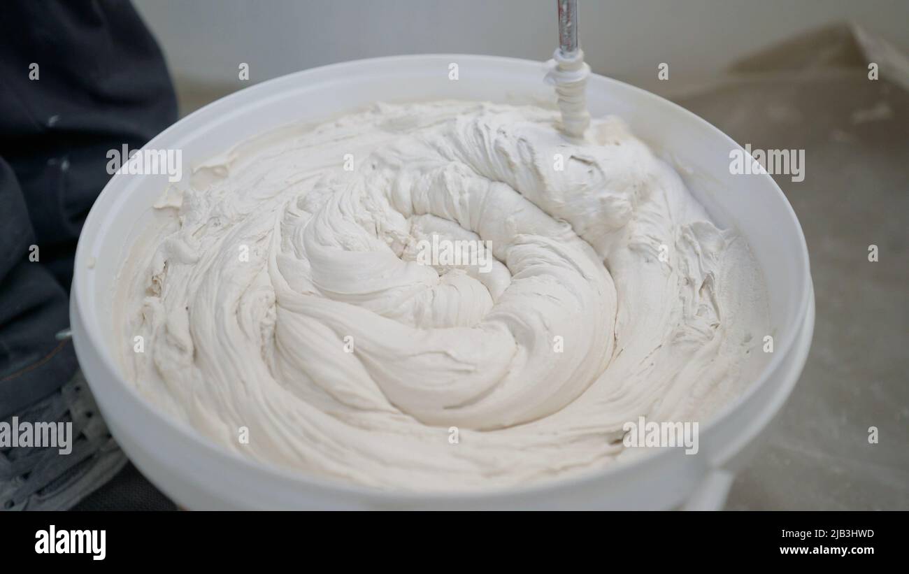White putty in a bucket. White putty in a bucket. Preparation of a ...