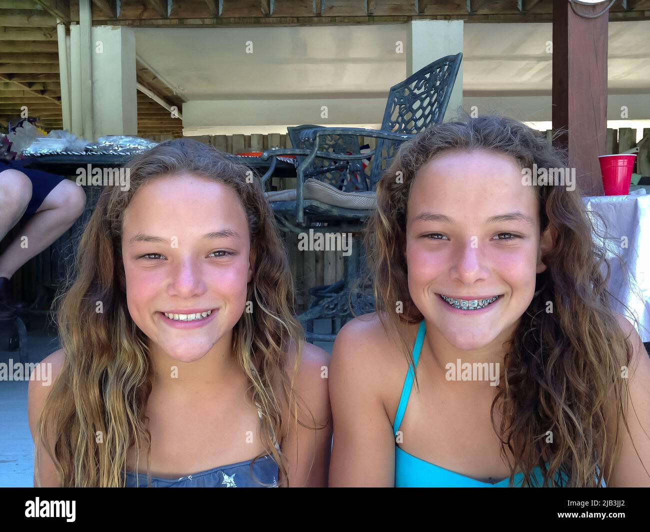 Identical twin sisters smiling at the camera. Model Released Stock ...