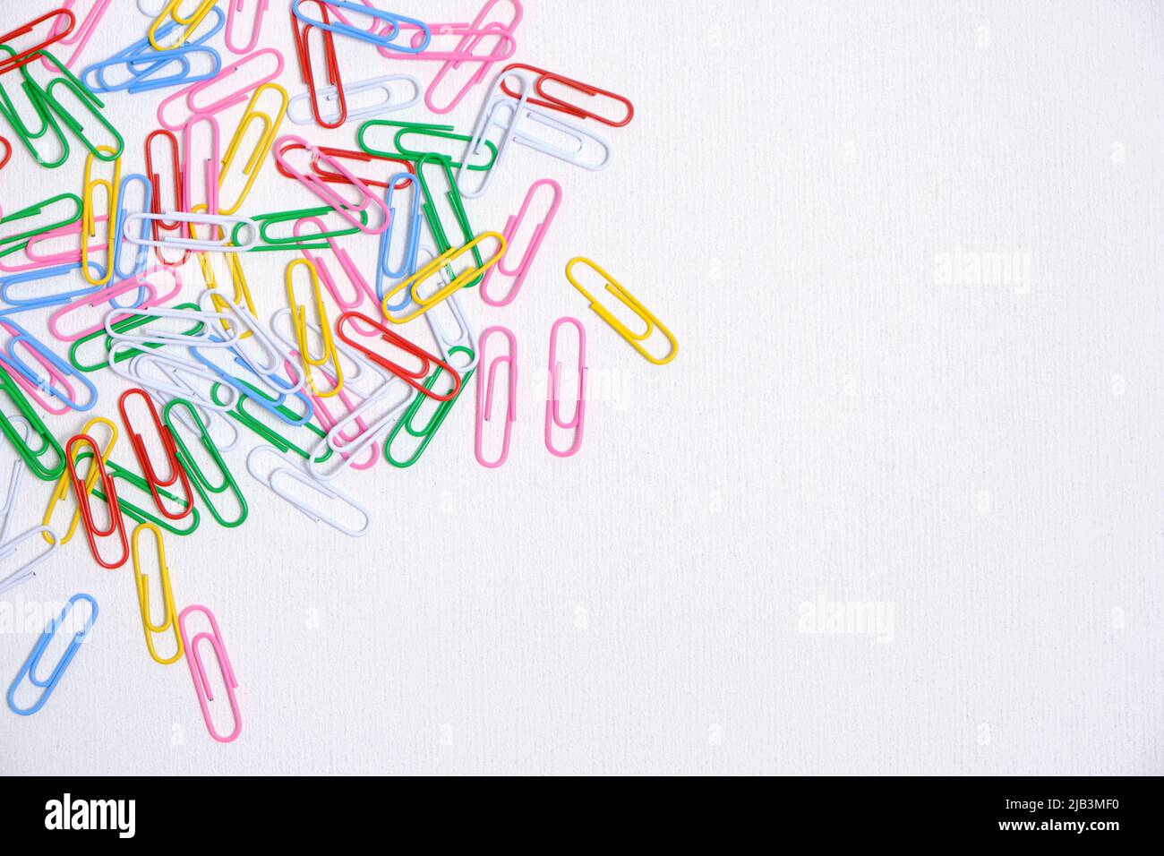 Colored paper clips on a white background Stock Photo - Alamy