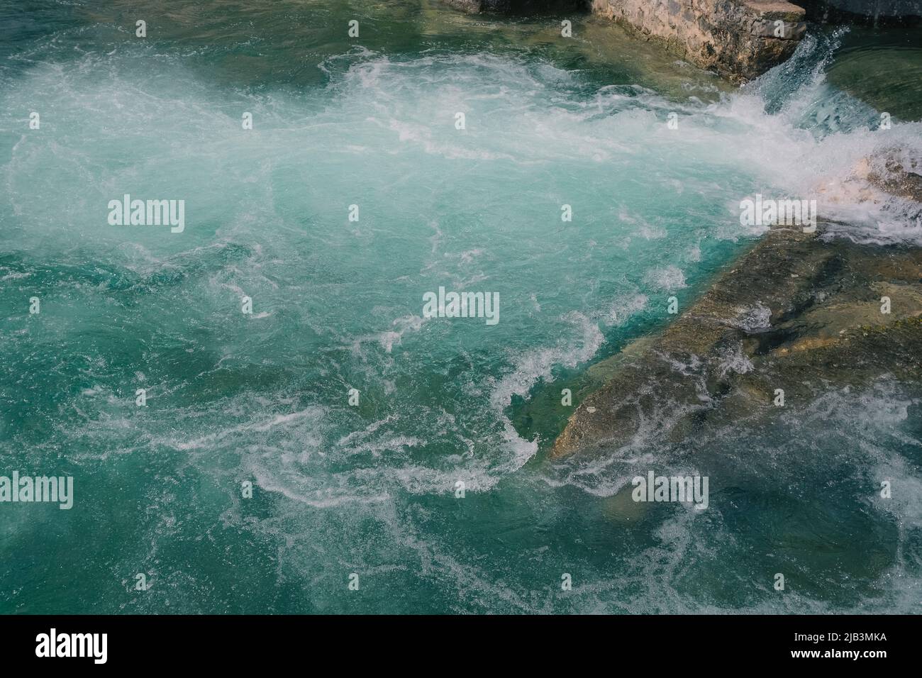 wave breaking on the rocks, crystal clear emerald sea water. river flow ...