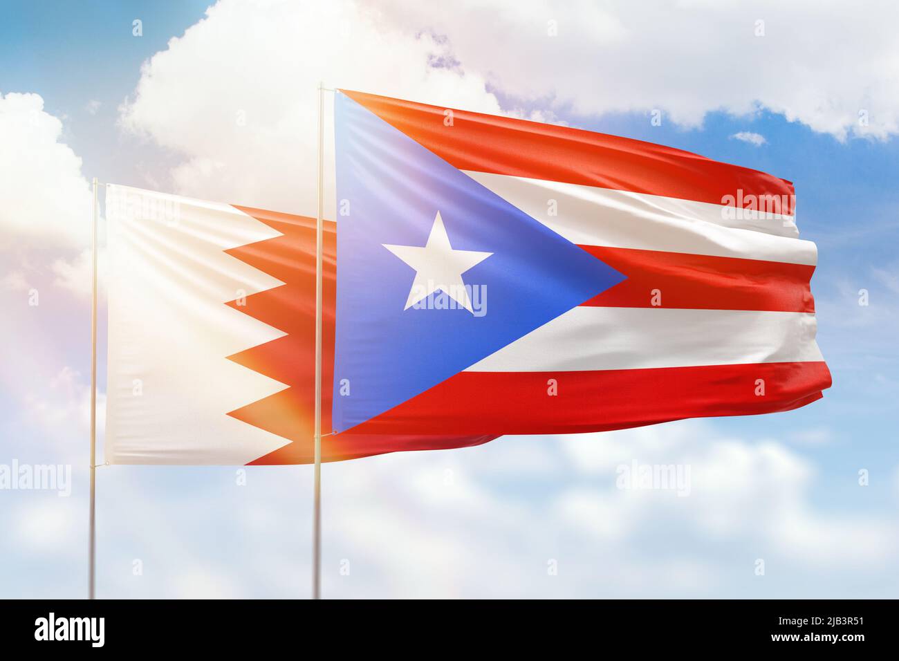 Sunny blue sky and flags of puerto rico and bahrain Stock Photo - Alamy