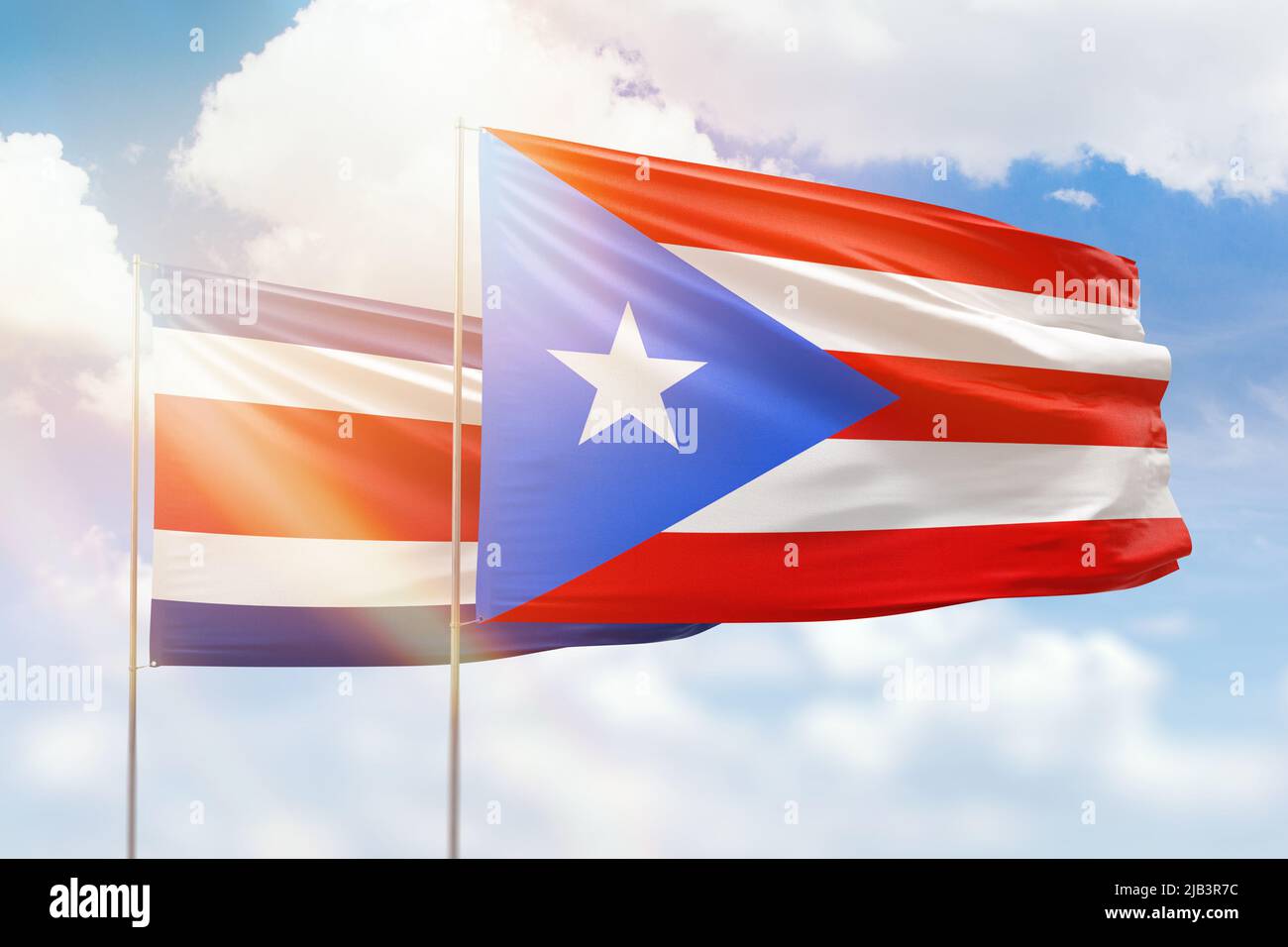 Sunny blue sky and flags of puerto rico and costa rica Stock Photo - Alamy