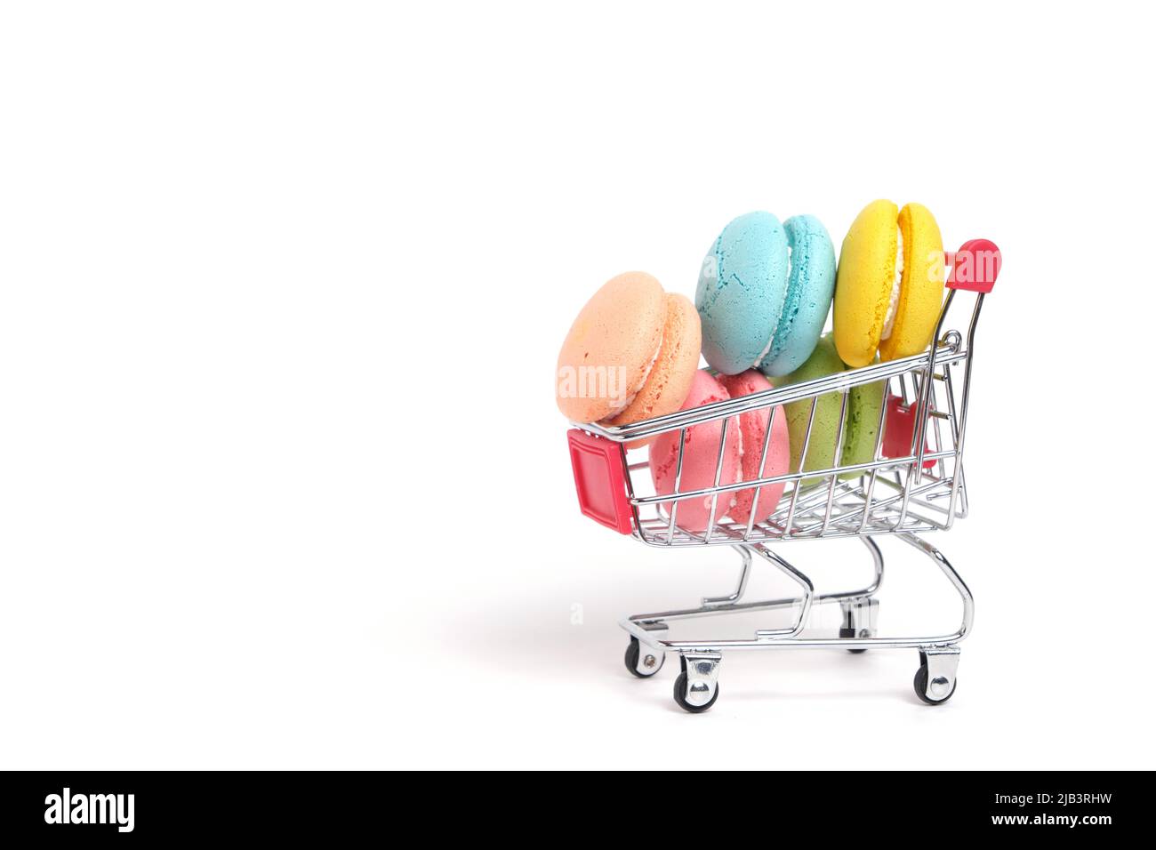 French macarons cookies in a shopping cart on a white background Stock ...