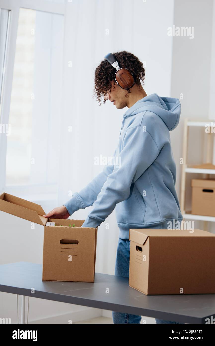 portrait of a man unpacking things from boxes in the room interior ...