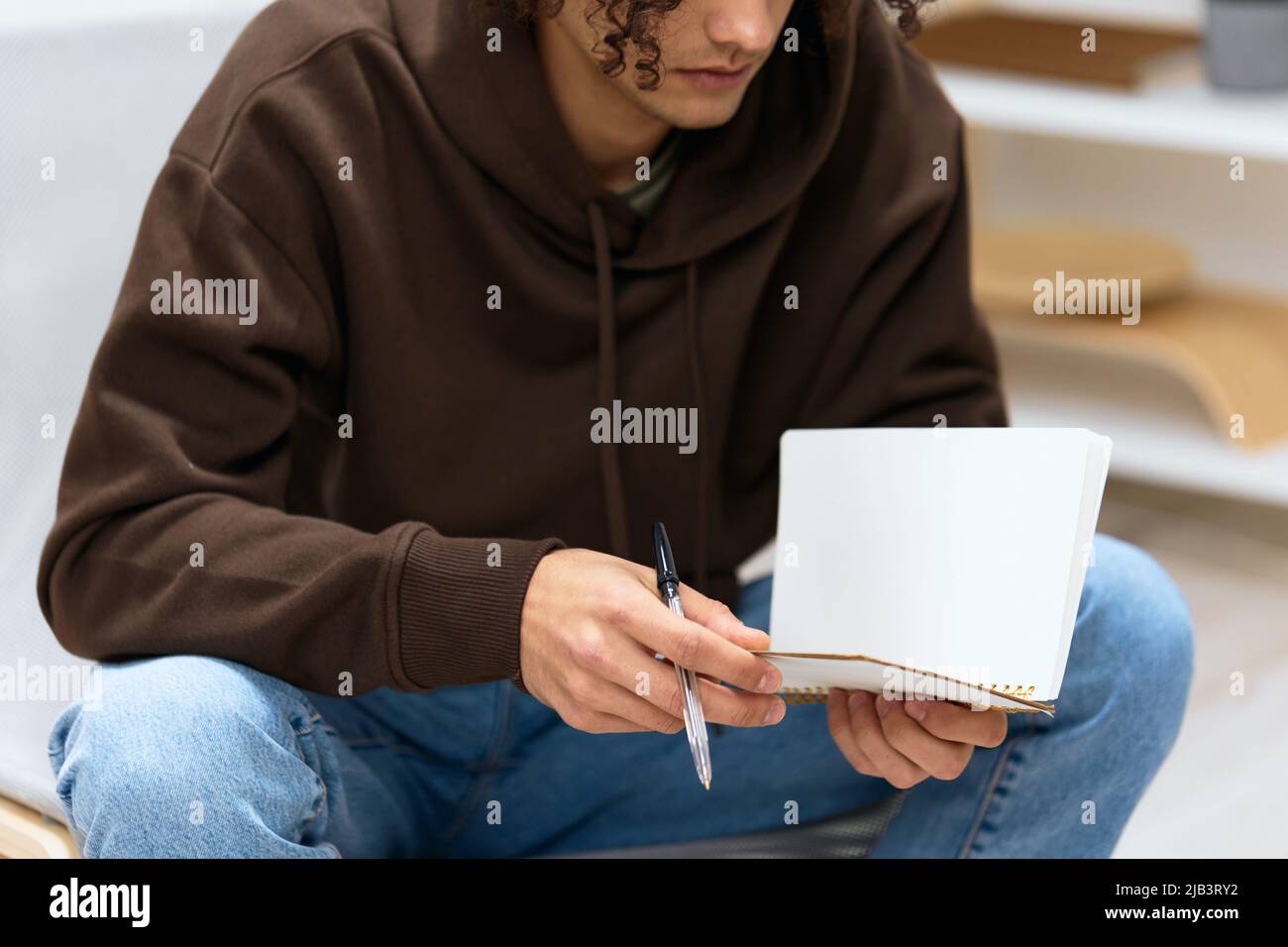 guy with curly hair writing down ideas with a notepad isolated ...