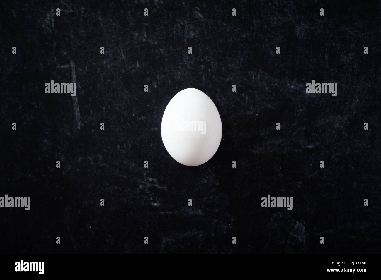 Top view of simple organic white egg on dark moody background Stock ...