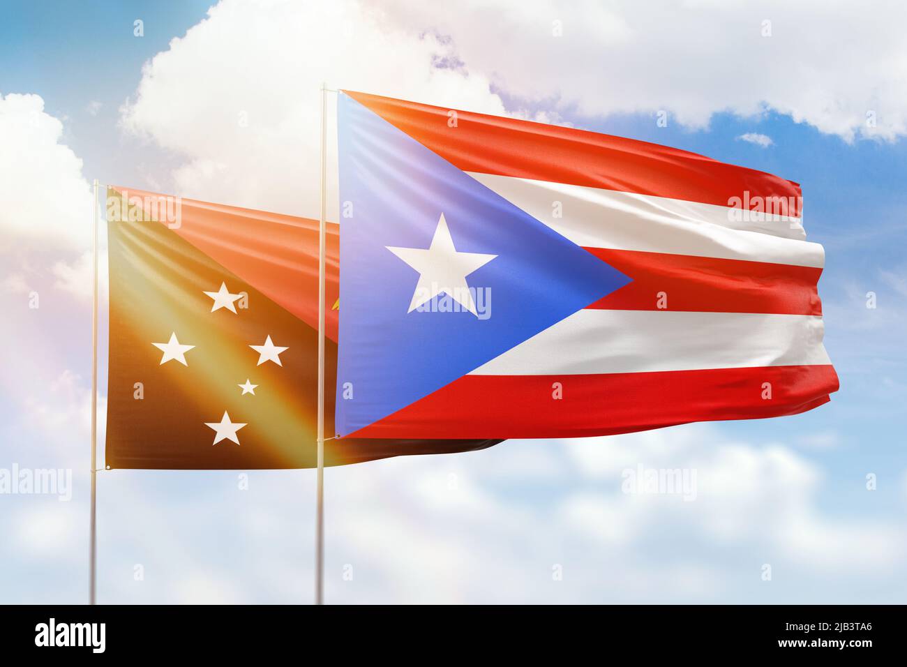 Sunny blue sky and flags of puerto rico and papua new guinea Stock ...