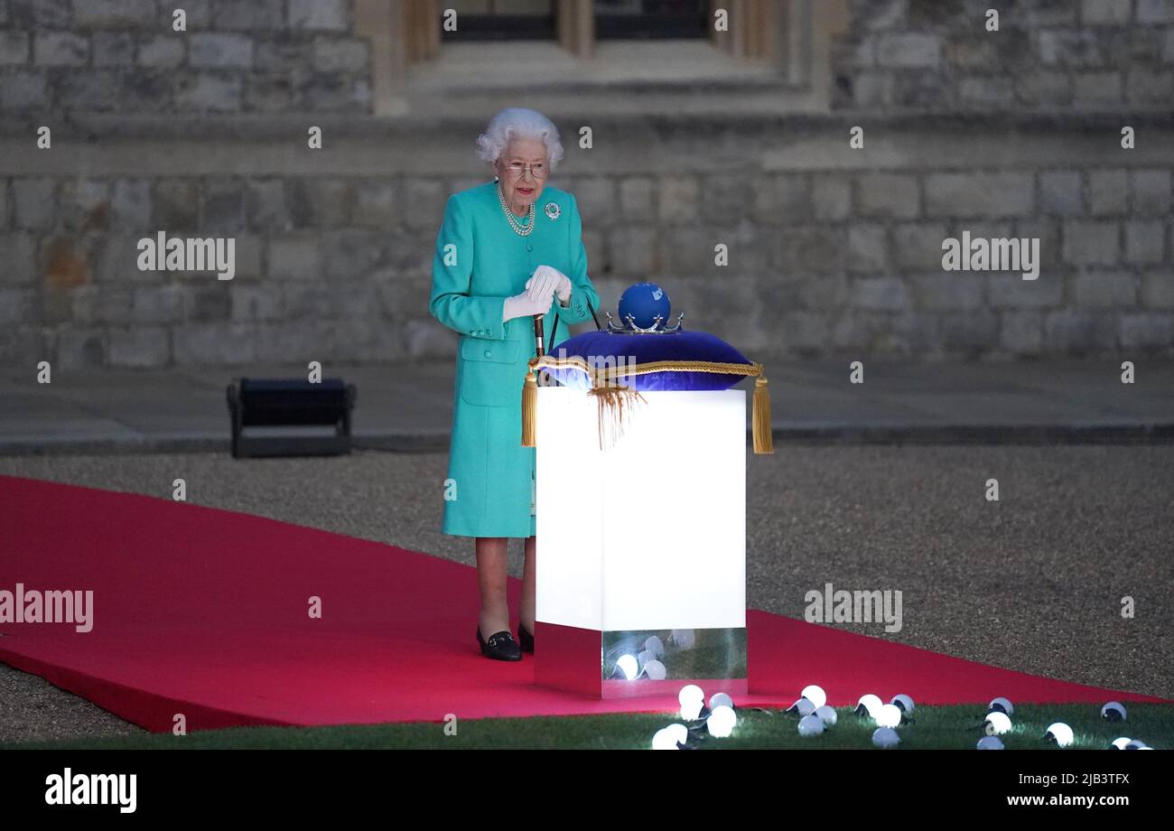 Queen Elizabeth II symbolically leads the lighting of the principal ...
