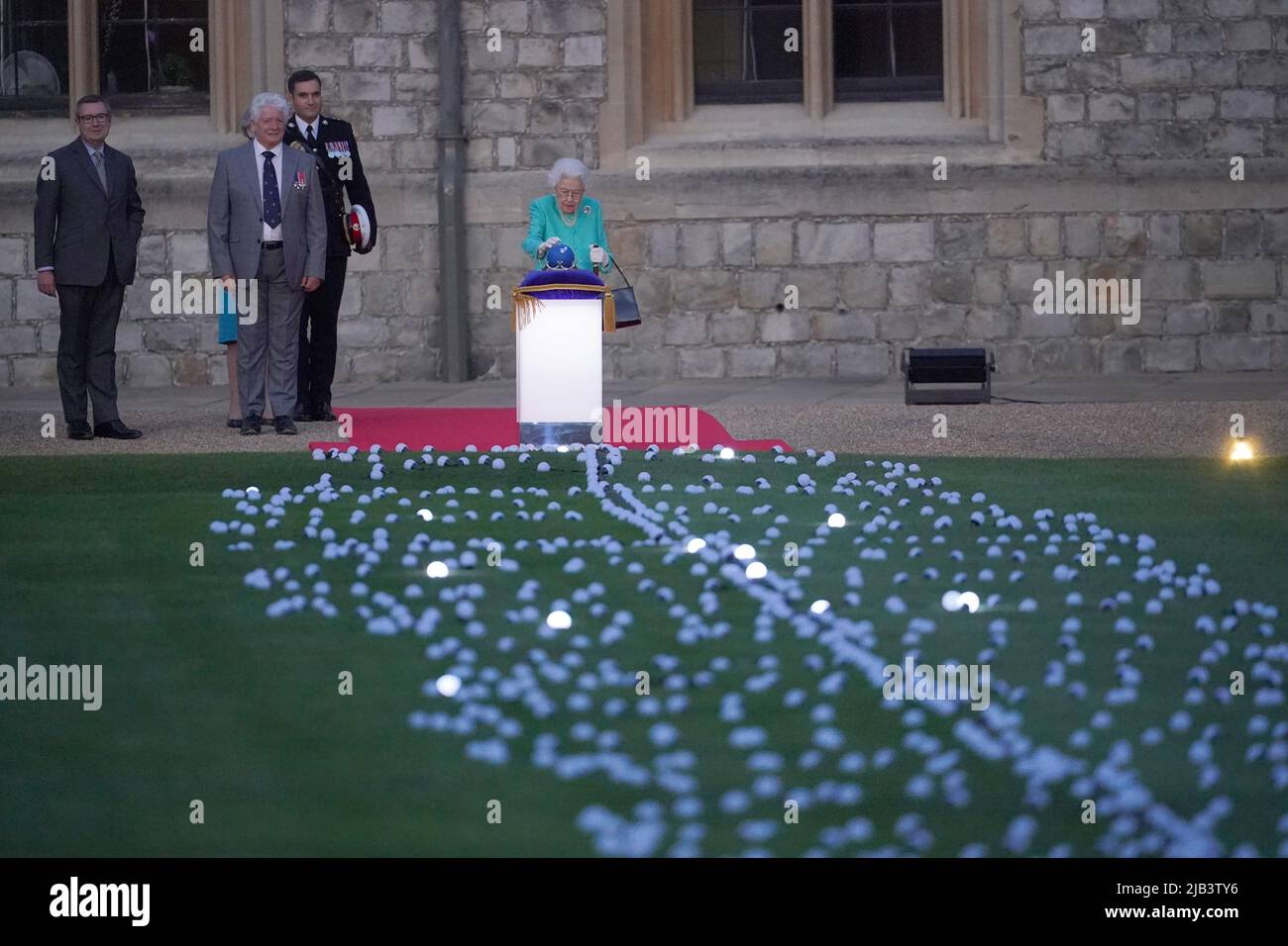 Queen Elizabeth II symbolically leads the lighting of the principal ...