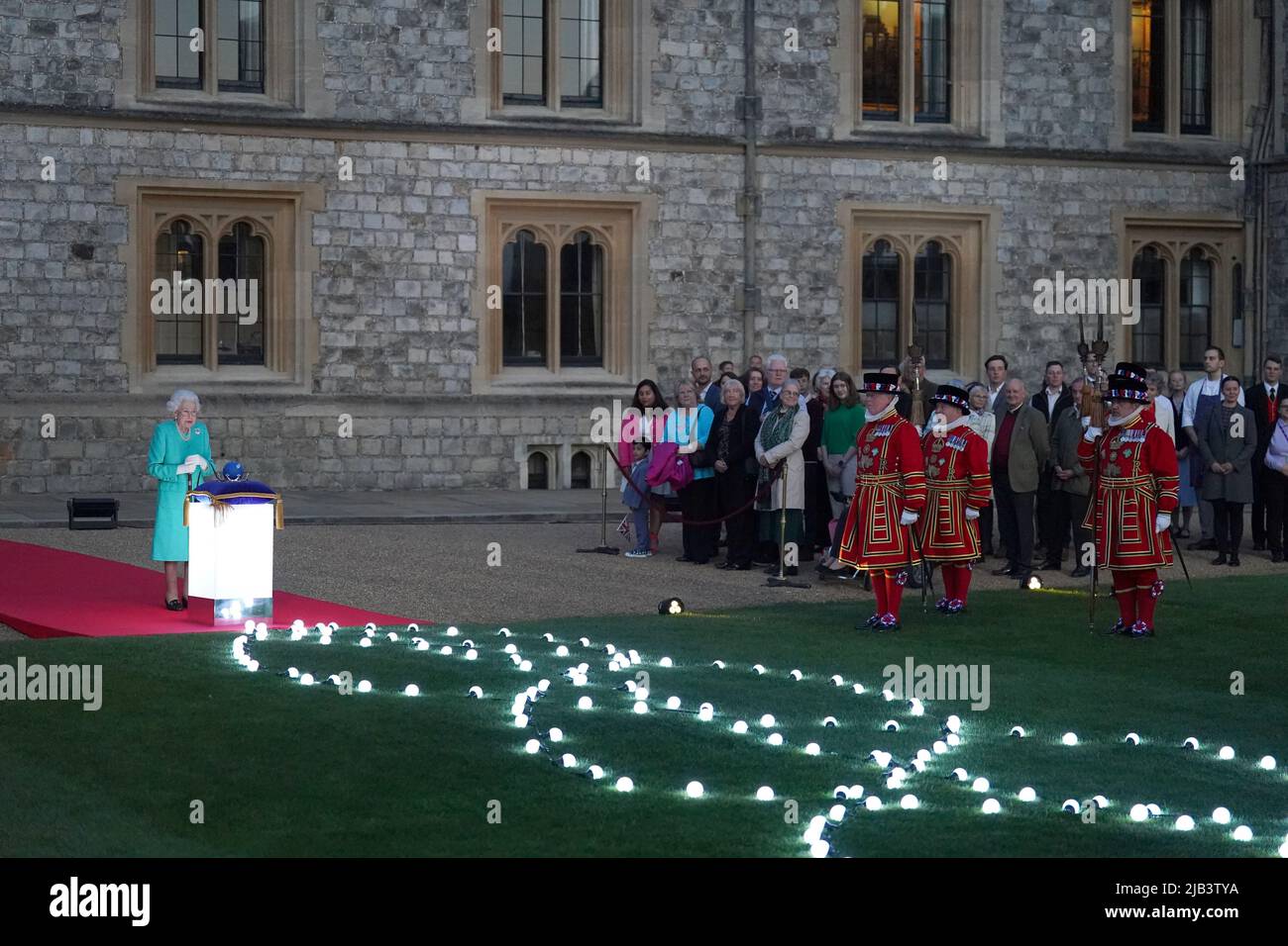 Queen Elizabeth II symbolically leads the lighting of the principal ...
