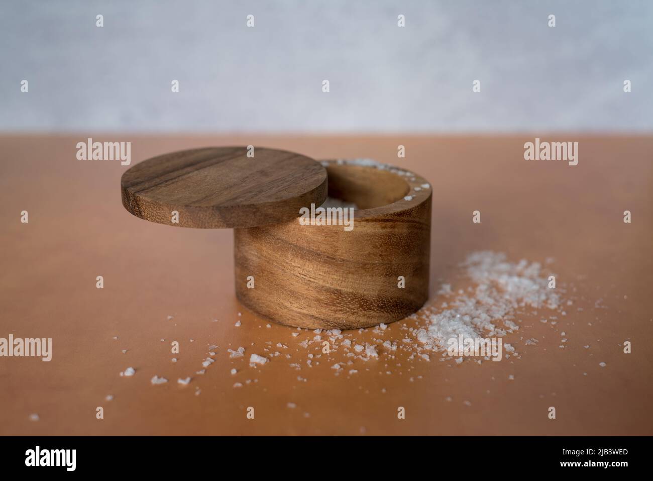 Side closeup view of sea salt on orange terracotta concrete background ...