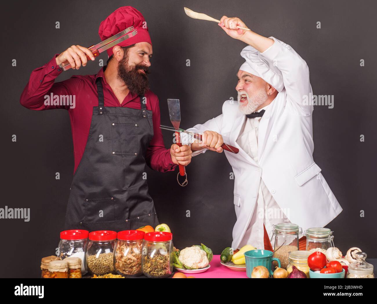 Two chefs in uniform fighting with kitchen utensils. Cooking. Culinary ...
