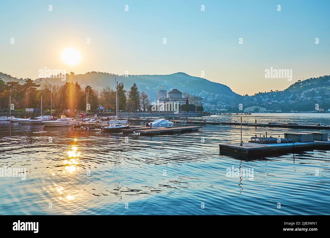 The golden sunset sun is reflected on rippled waters of Lake Como, Como ...