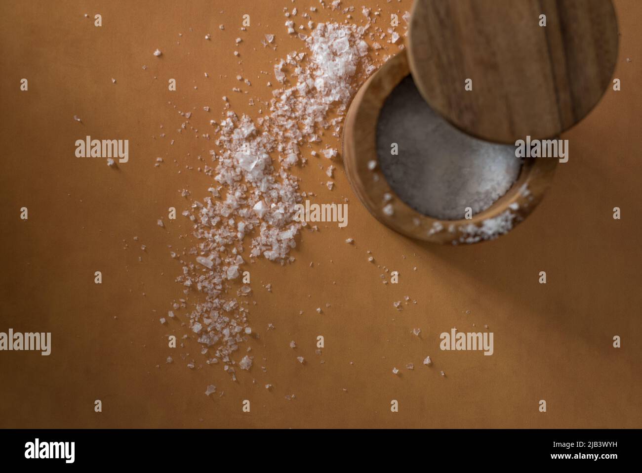 Top view of sea salt on orange terracotta background inside round ...