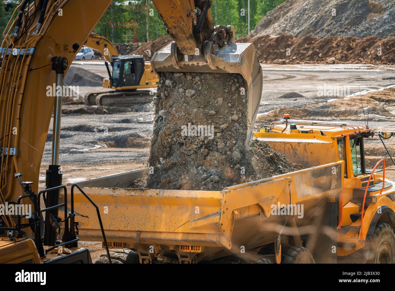 Excavator bucket - loading soil to dump truck, close up photo Stock ...