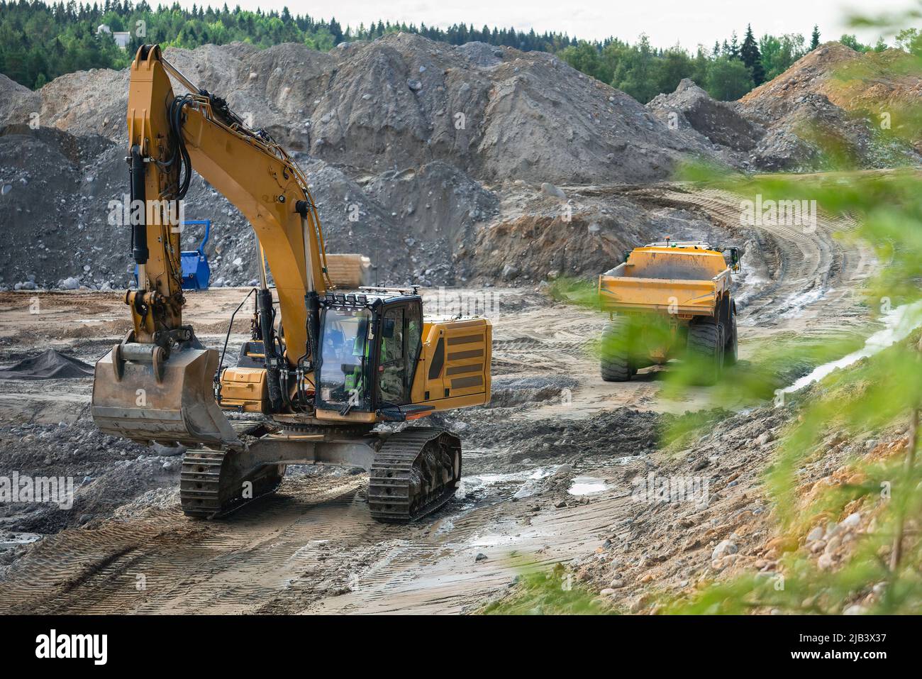 Big dump truck waits for loading by excavator - ground preparing for ...