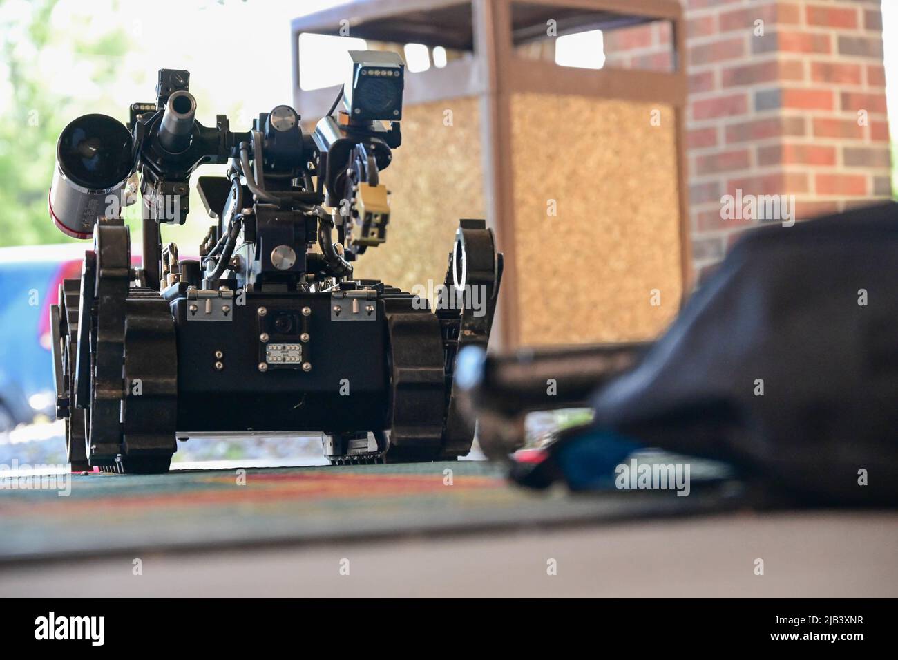 An explosives robot rolls up to a backpack left at the front doors of ...